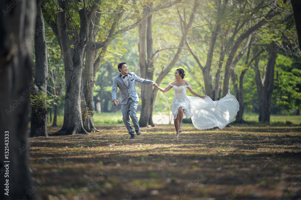 Bride and groom running and park and holding hands Stock Photo | Adobe ...
