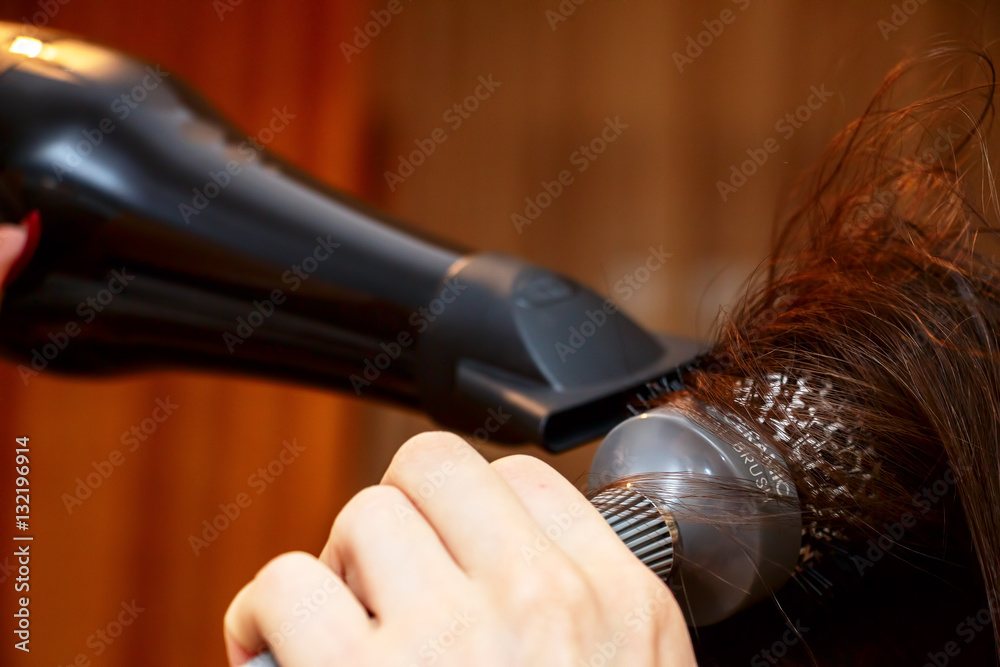 Girl dries hair and makes your hair with a comb Stock Photo | Adobe Stock