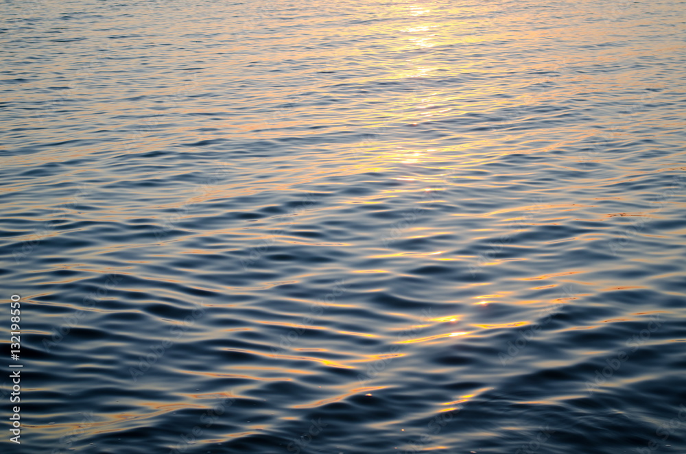 Texture of sea water at sunset, blue and orange colors of sun path ...