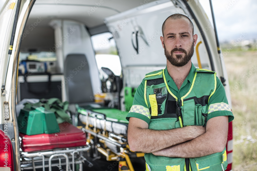 Paramedic standing with arms crossed in front of ambulance Stock Photo ...