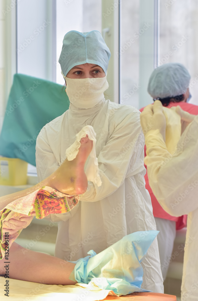 Fotka „Operation/Chief nurse, assists the doctor - traumatologist. She ...