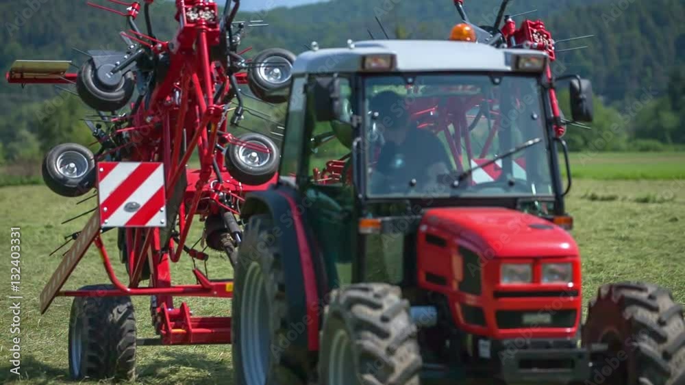 A man is driving a tractor and he is pulling a big agricultural ...