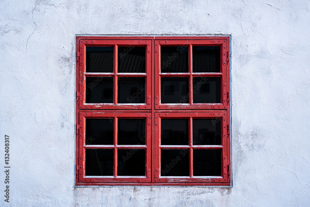 Old red weathered window with squares on white wall with worn texture ...