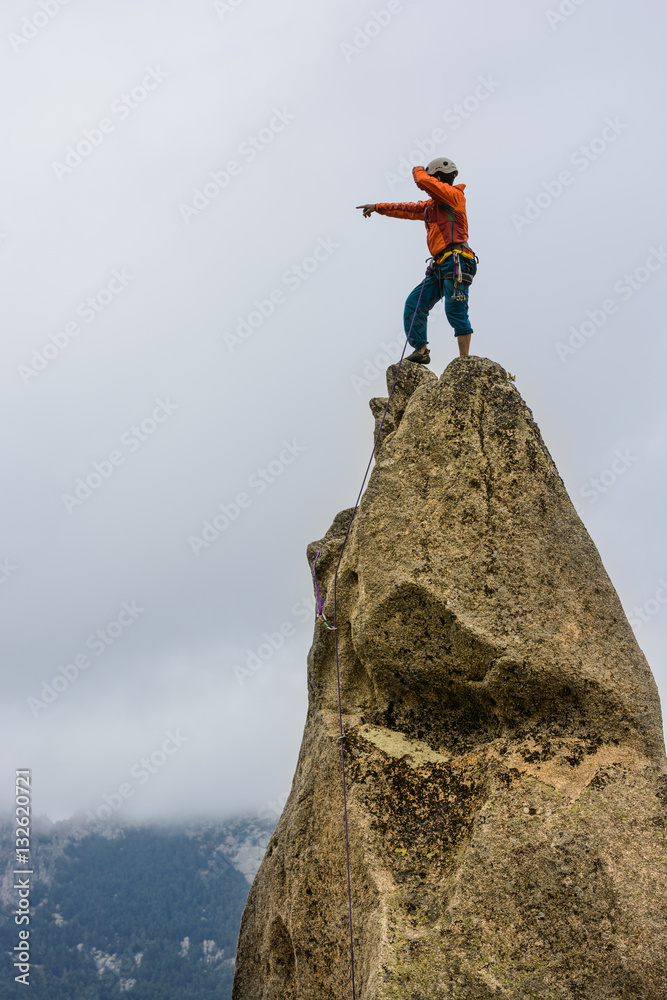 Man climbed on a rock pointing towards a discovery on the horizon Stock ...