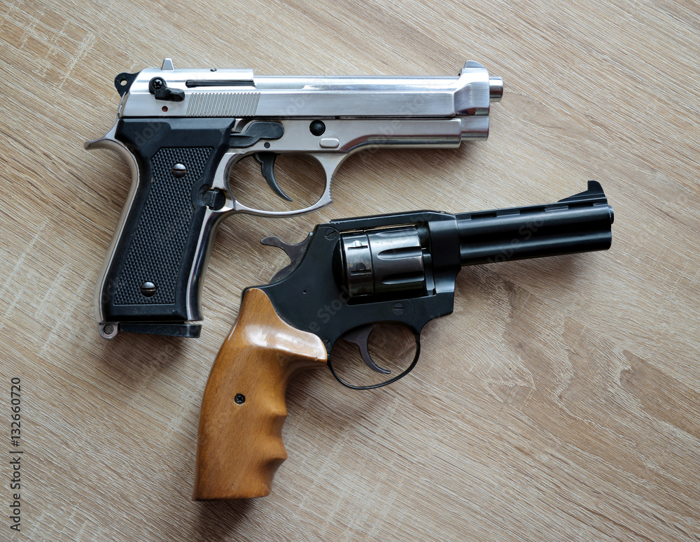 Two pistols on wooden board. foto de Stock | Adobe Stock
