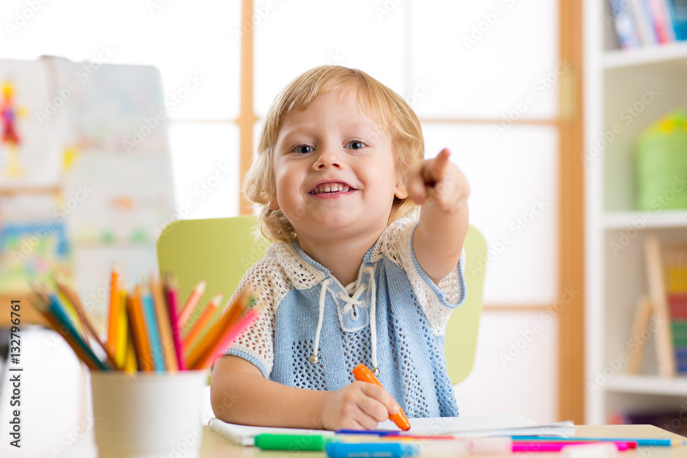 cute child little boy drawing with felt-tip pen in kindergarten ...