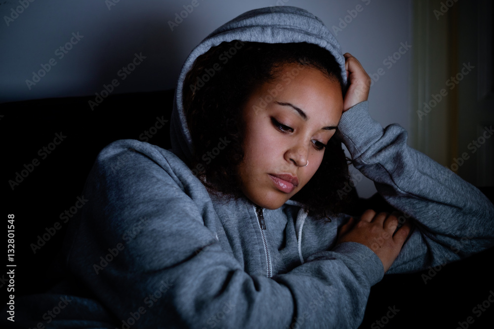 Sad woman lying on the couch at night Stock Photo | Adobe Stock
