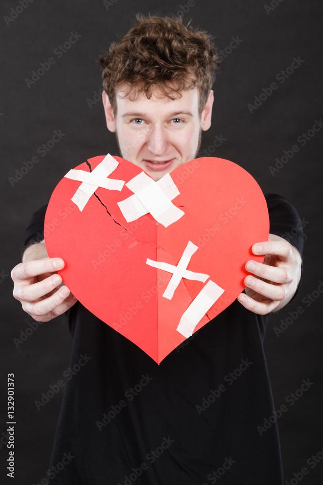 Very sad young man holding broken heart Stock Photo | Adobe Stock