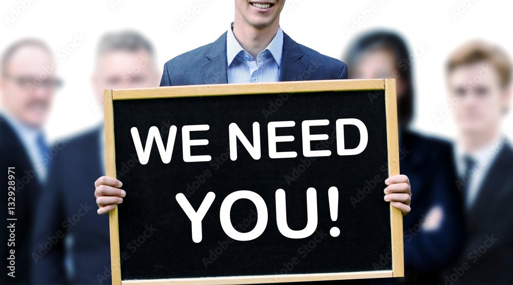 young businessman holding a sign with the words We Need You Stock Photo ...