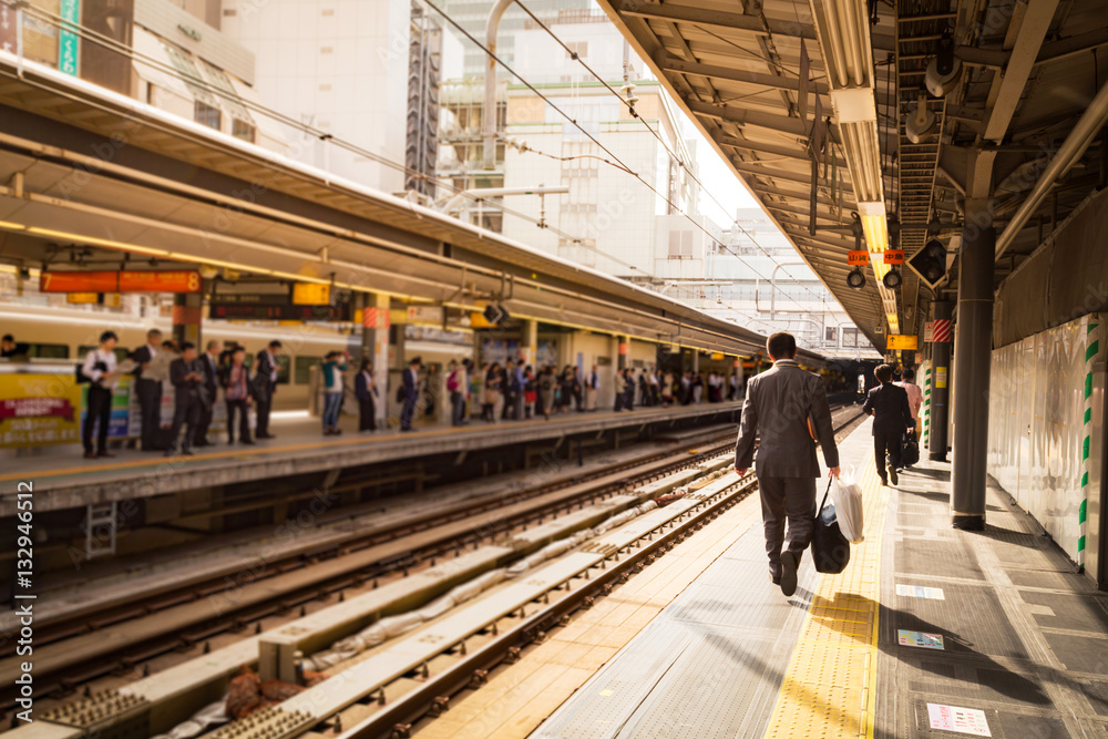 businessman arriving at the train station in the morning sunlight and ...