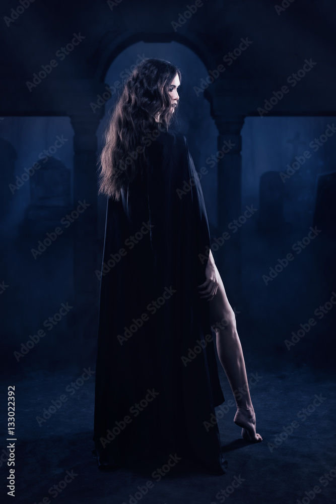 Beautiful gothic girl in a black cloak against a nightscape in t Stock ...