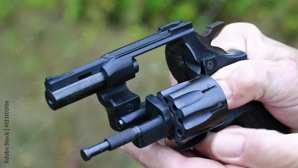 Man turns cylinder of black revolver. Man with black gun, close up. Man ...