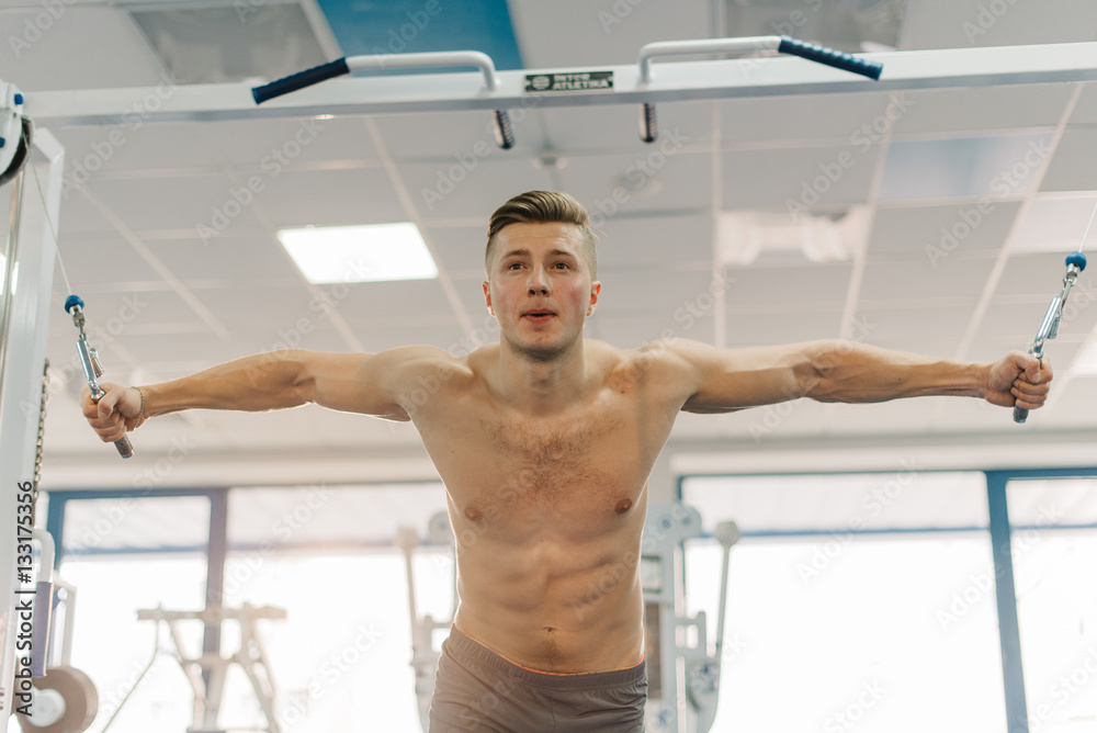 close up photo of attractive man training on Fitness-station. Guy with ...