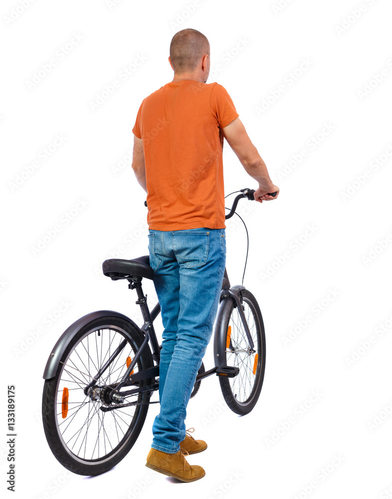 back view of a man with a bicycle. Cyclist keeps the wheel of a bicycle ...