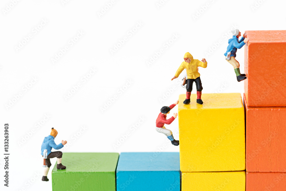 Miniature climbers team climbing on stack of cube building block Stock ...