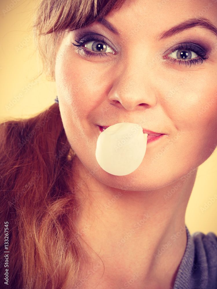 Blonde girl chewing gum making balloon. Stock Photo | Adobe Stock