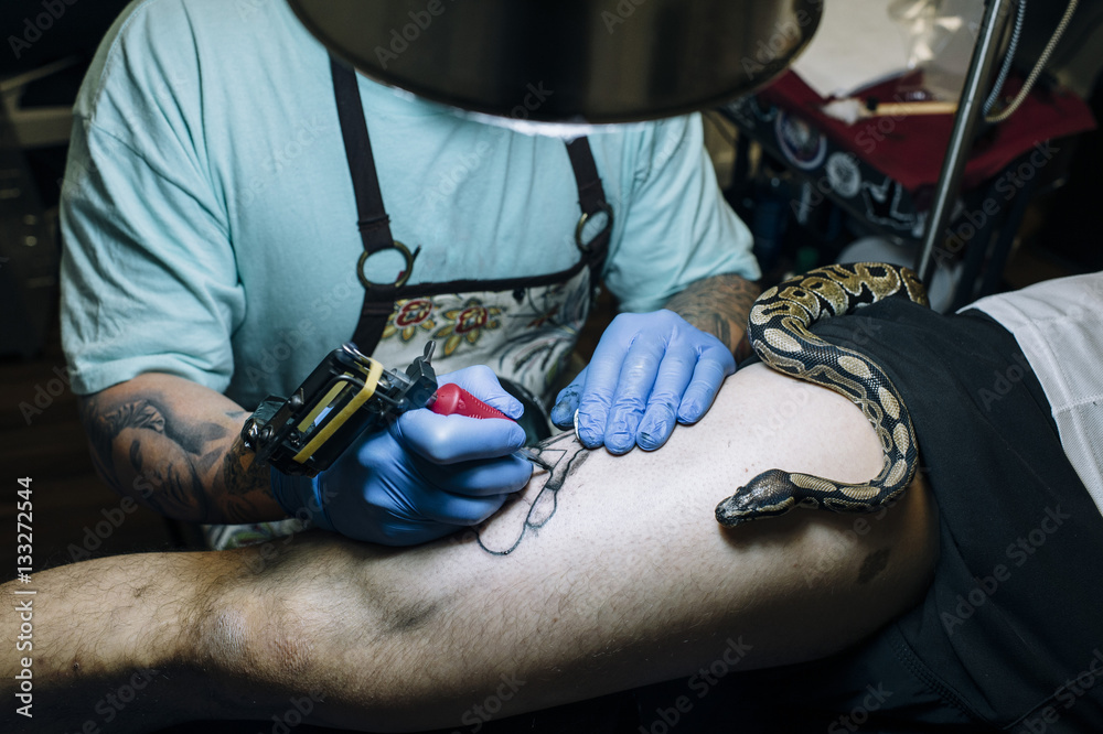 Tattoo master with snake Stock Photo | Adobe Stock
