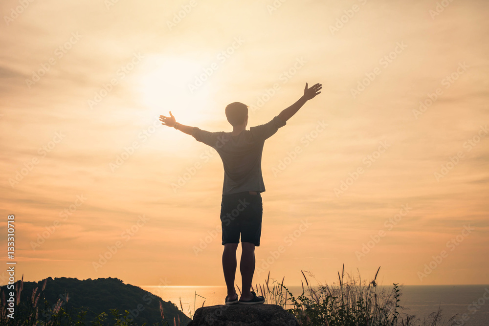 Silhouette of a man with hands raised in the sunset concept for ...