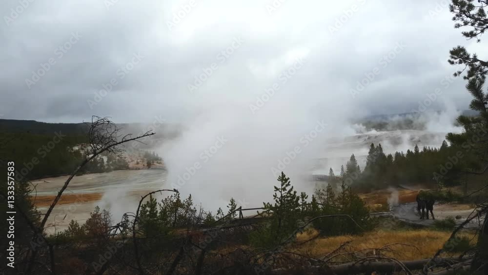 People walking at a field full of smoking geysers, in Yellowstone ...