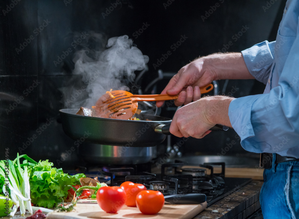 Man mixing food in a pan Stock Photo | Adobe Stock