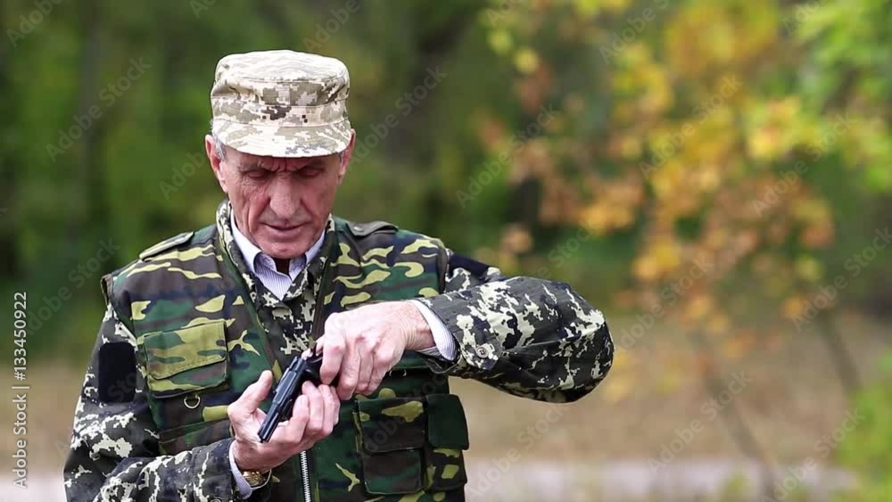 Man in military uniform checks his revolver and shoots. Man with black ...