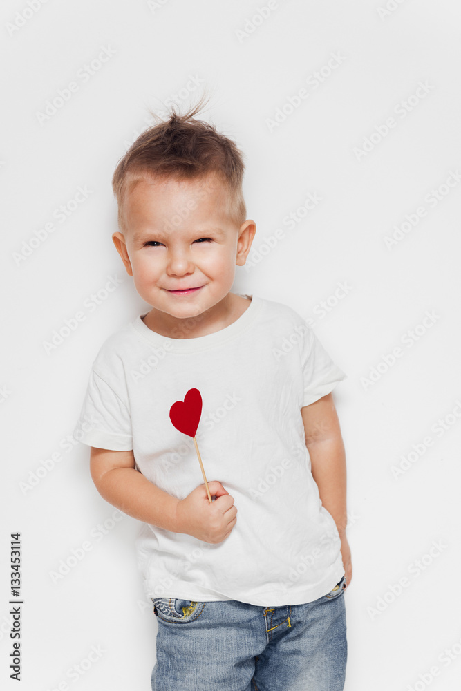 Cute little boy holding heart shape on stick against white background ...