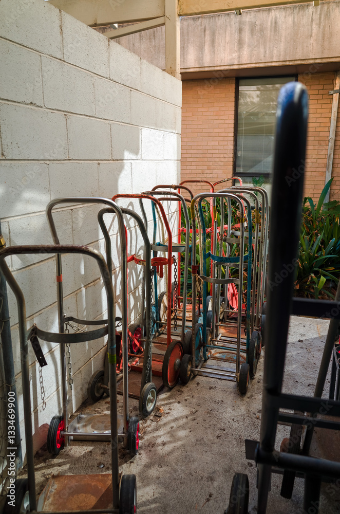 Hand trolleys in storage. Row of upright trolley in storage room. Hand ...