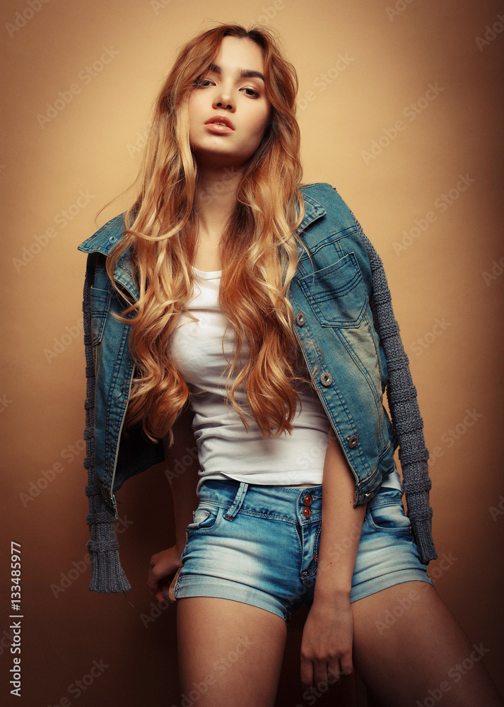 Fashion model in nice clothes posing in the studio on yellow background ...