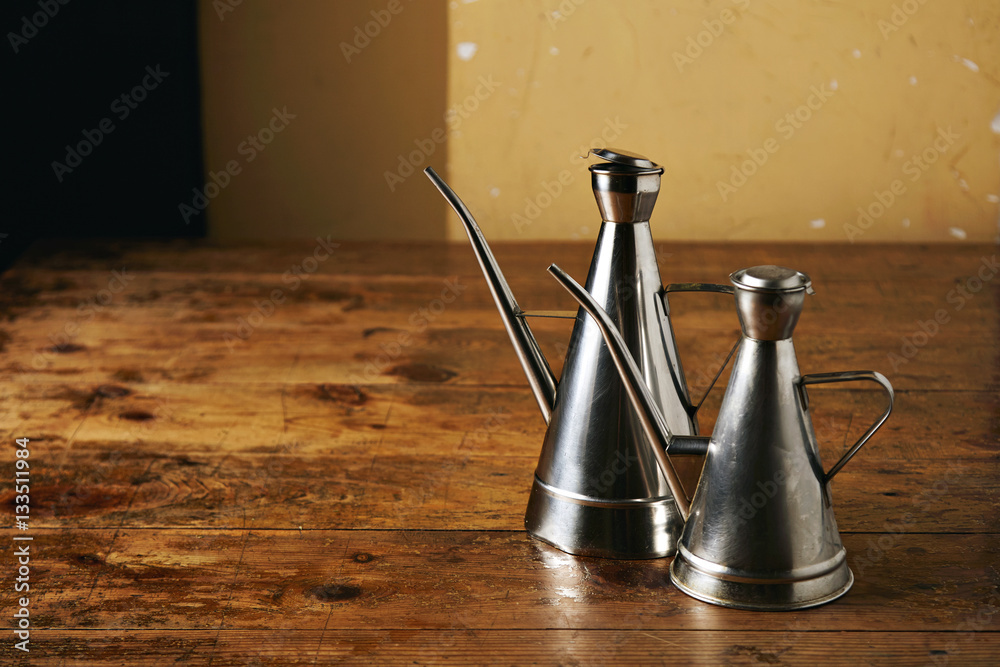 Two shiny steel made vintage and different sized metal olive oil ...