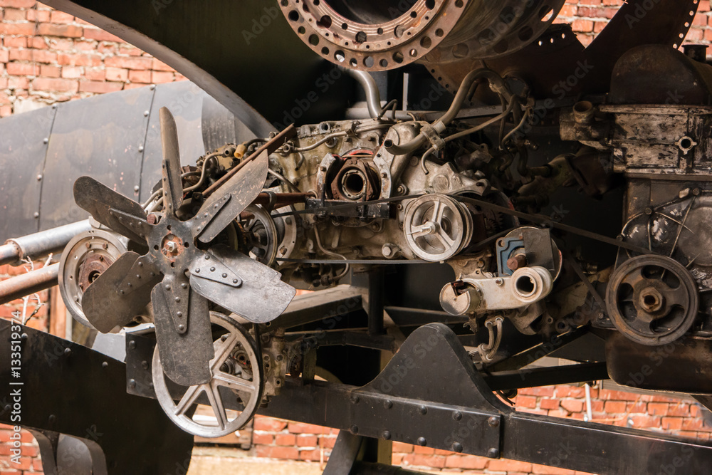 Parts of old engine. Steel wheels and fan. Start the heart of machine ...