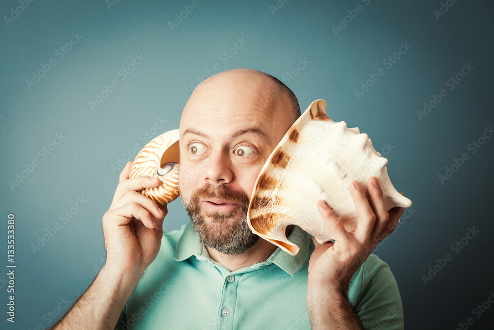 Bearded middle-aged man with shell listening noise of sea Stock Photo ...