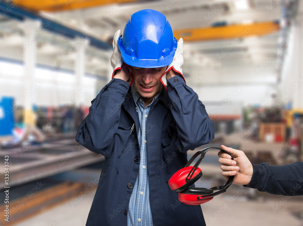 Worker protecting his ears from the noise Stock-Foto | Adobe Stock