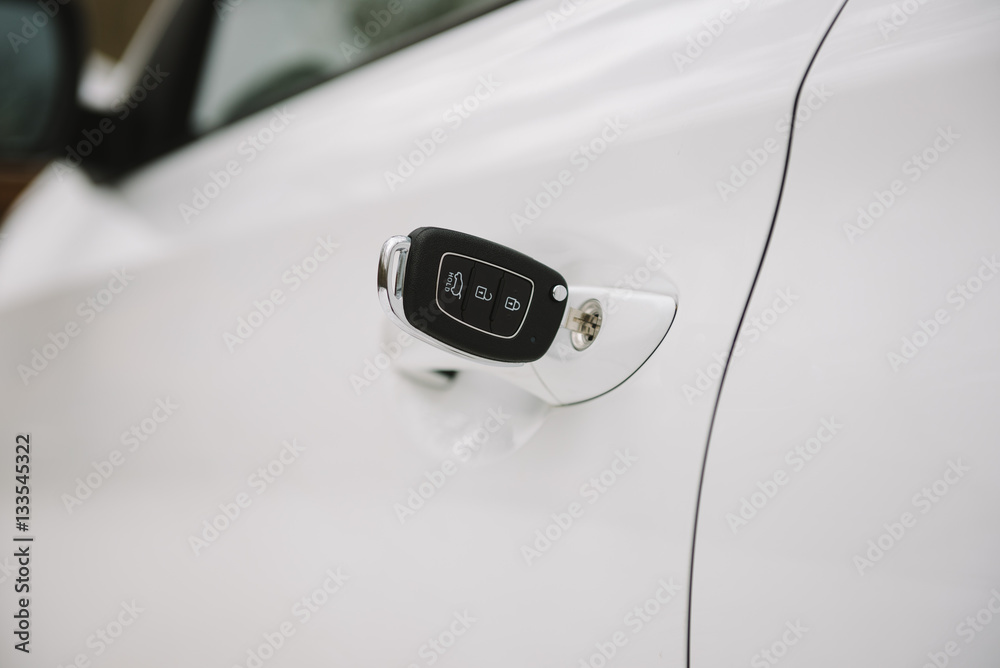 Car keys in white door lock closeup with copy space. Opening car door ...