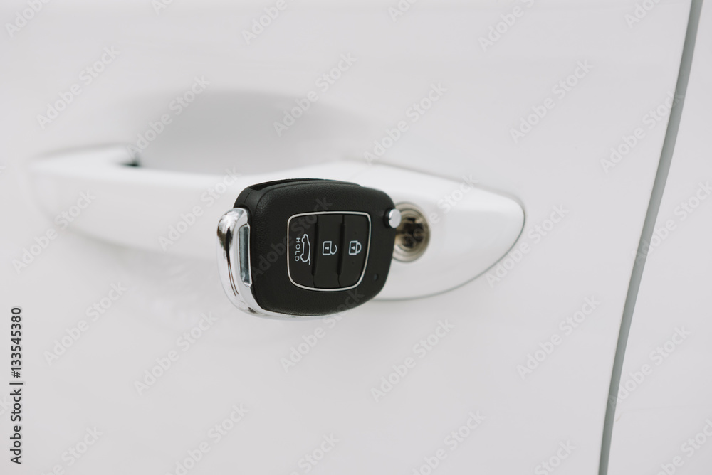 Car keys in white door lock closeup with copy space. Opening car door ...