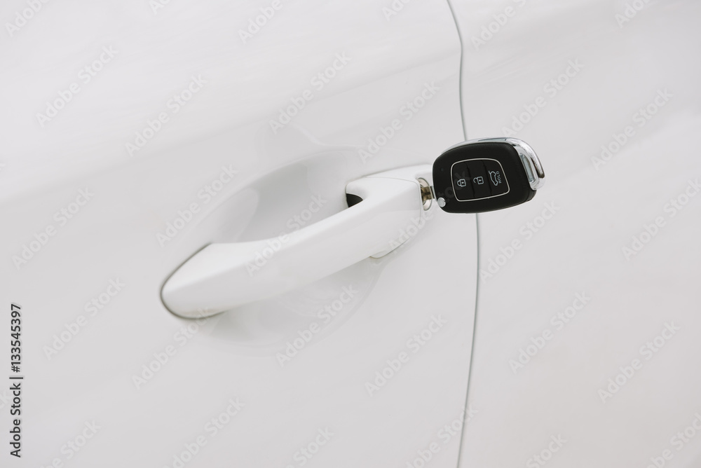 Car keys in white door lock closeup with copy space. Opening car door ...