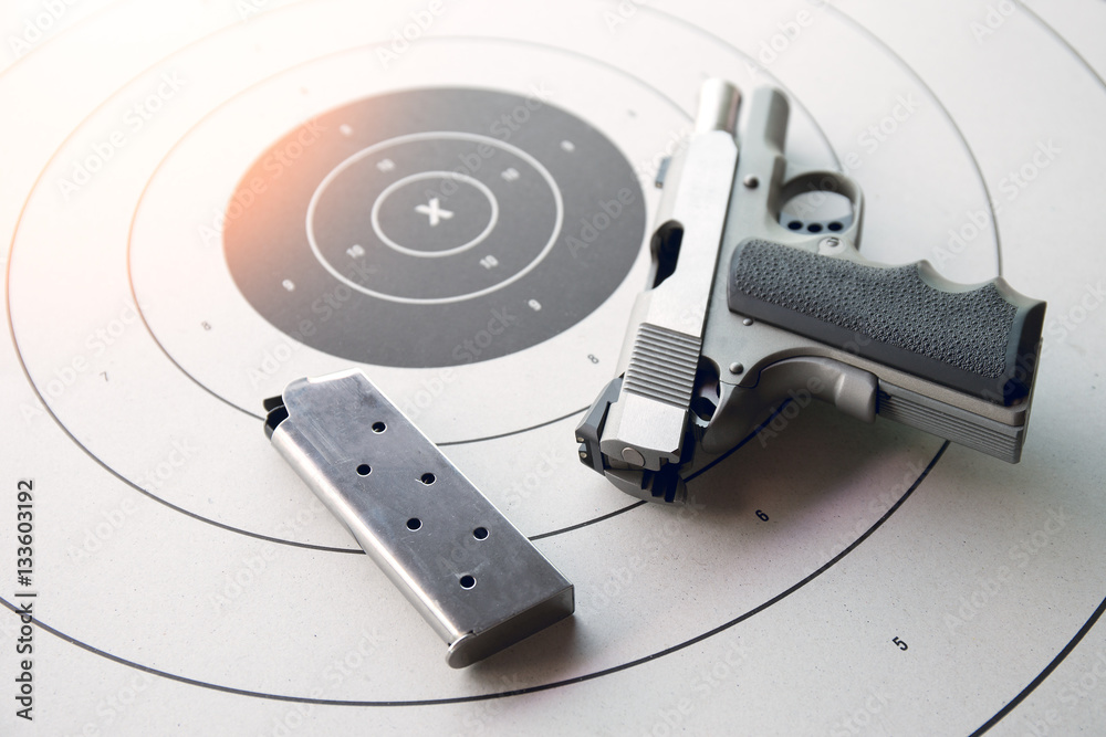 silver .45 pistol with magazine on bullseye target with flare Stock ...