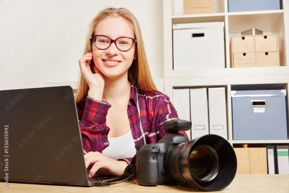 Photographer with laptop and camera in her office Stock Photo | Adobe Stock
