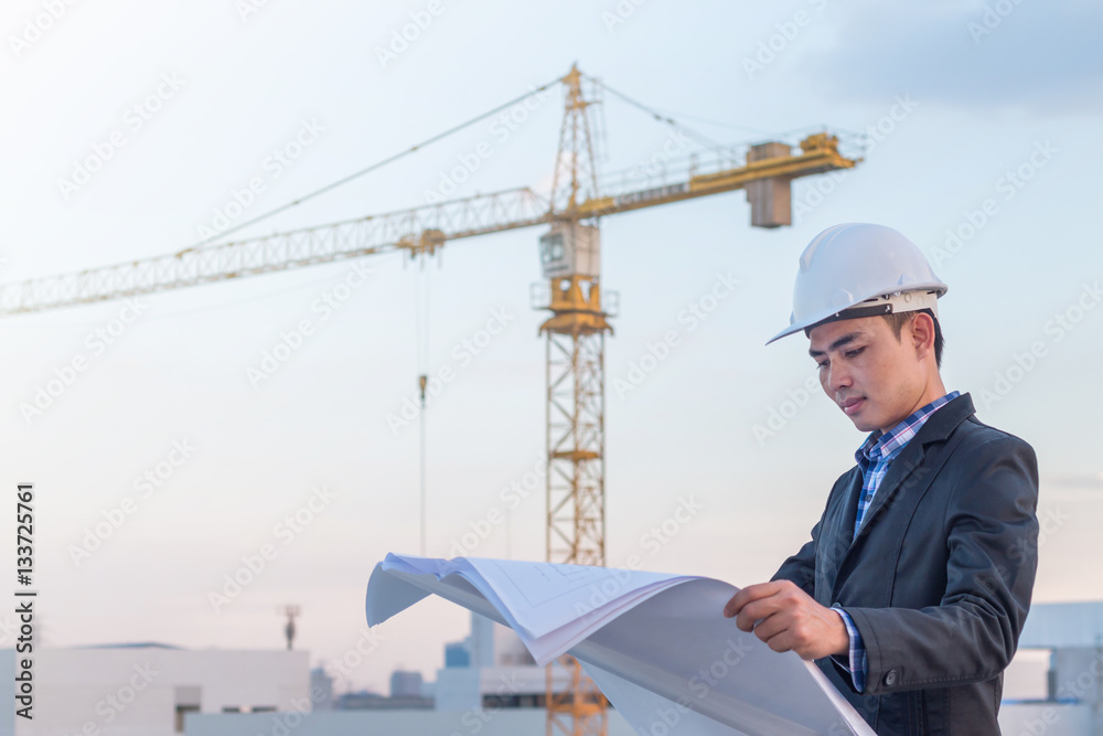 The architect wear white safety helmet and verify the blueprint Stock ...