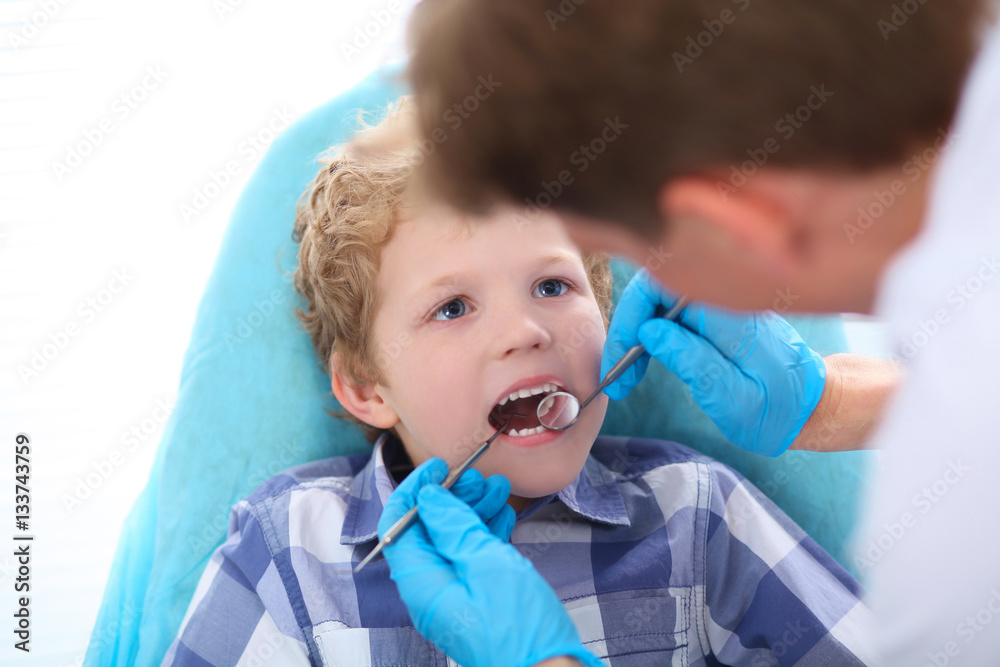 Close-up of little boy opening his mouth wide during inspection of oral ...