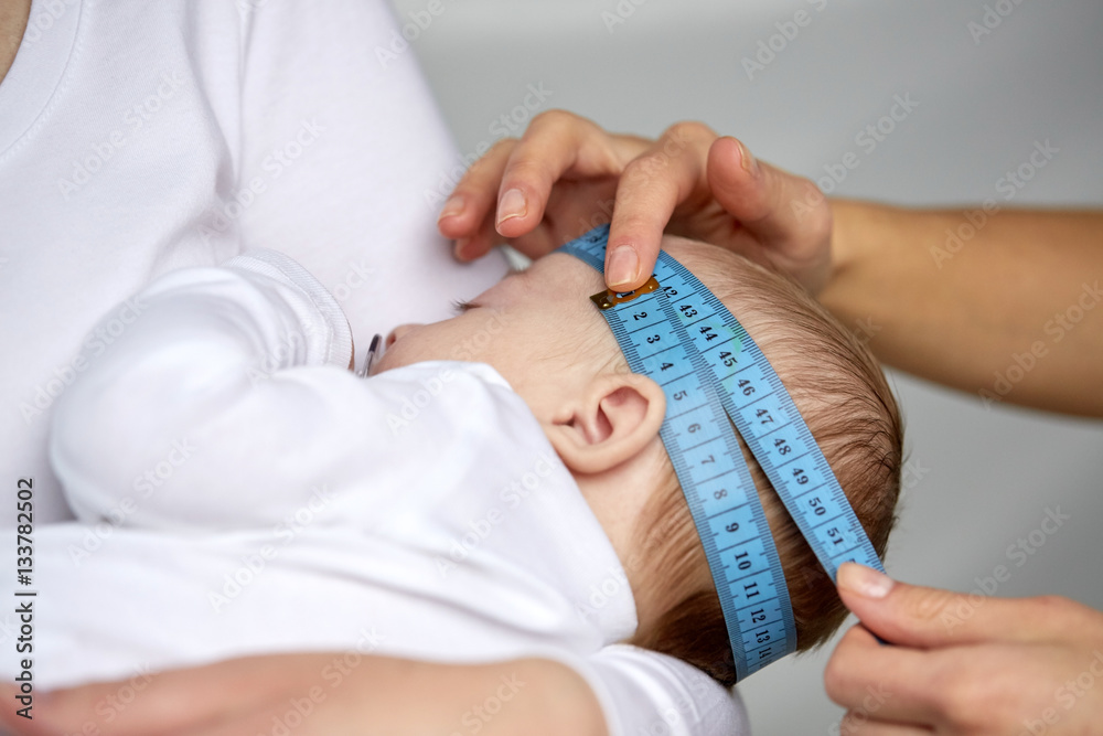 close up of hands with tape measuring baby head Stock-Foto | Adobe Stock