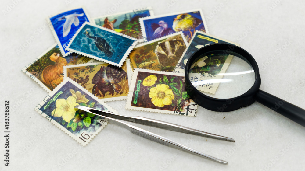 old postage stamps tweezer and magnifier Stock Photo | Adobe Stock