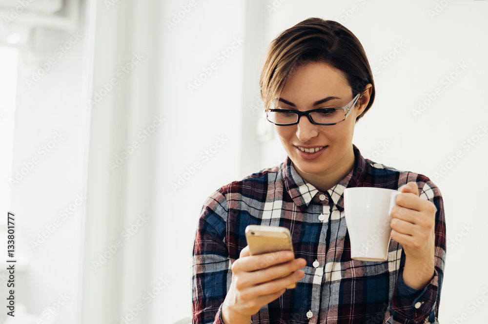 Young smiling female reading text message on mobile phone Stock Photo ...