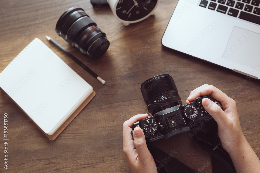 Camera on hand.Photographer workplace, Camera,Laptop,Memo on wooden ...
