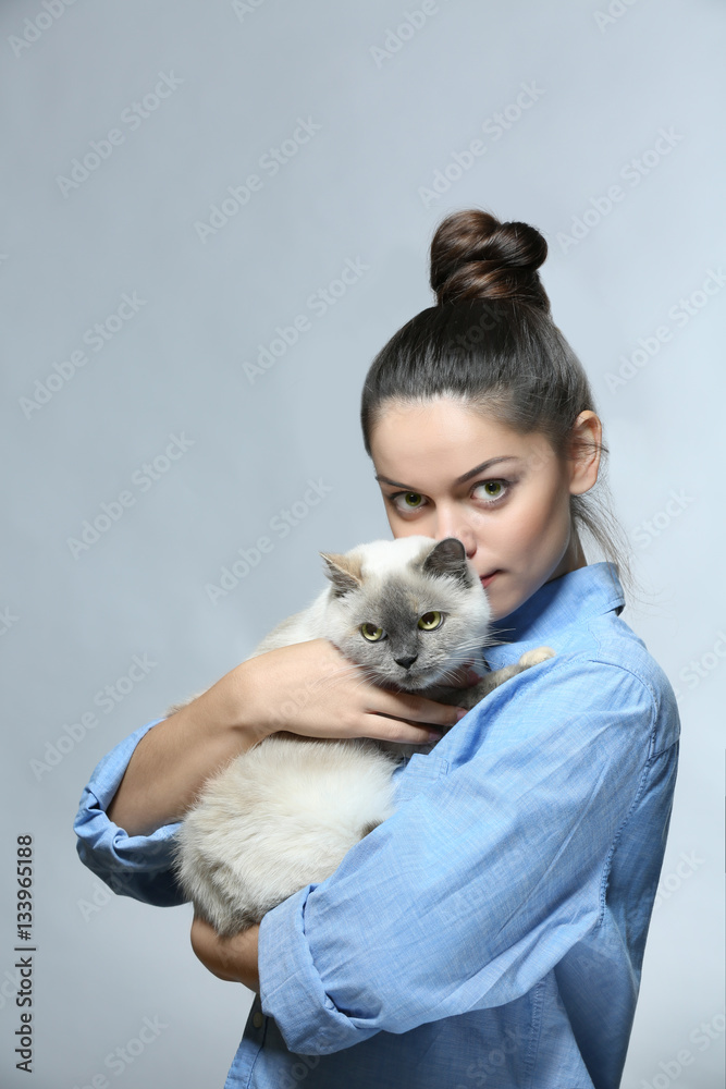 Beautiful young woman with cute cat on color background Stock-Foto ...