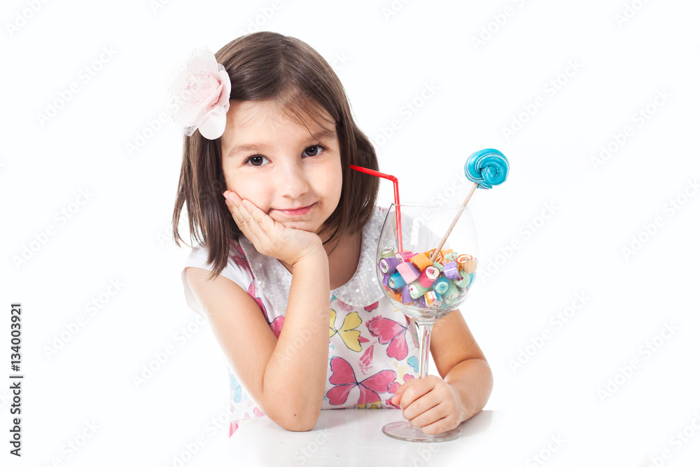 Pretty girl among the sweets, candies and lollipops. Funny child with ...