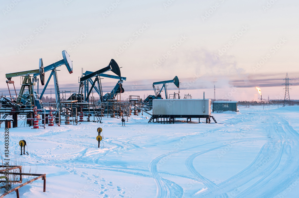 Oil Field. Winter industrial landscape with an oil pump and torch in ...