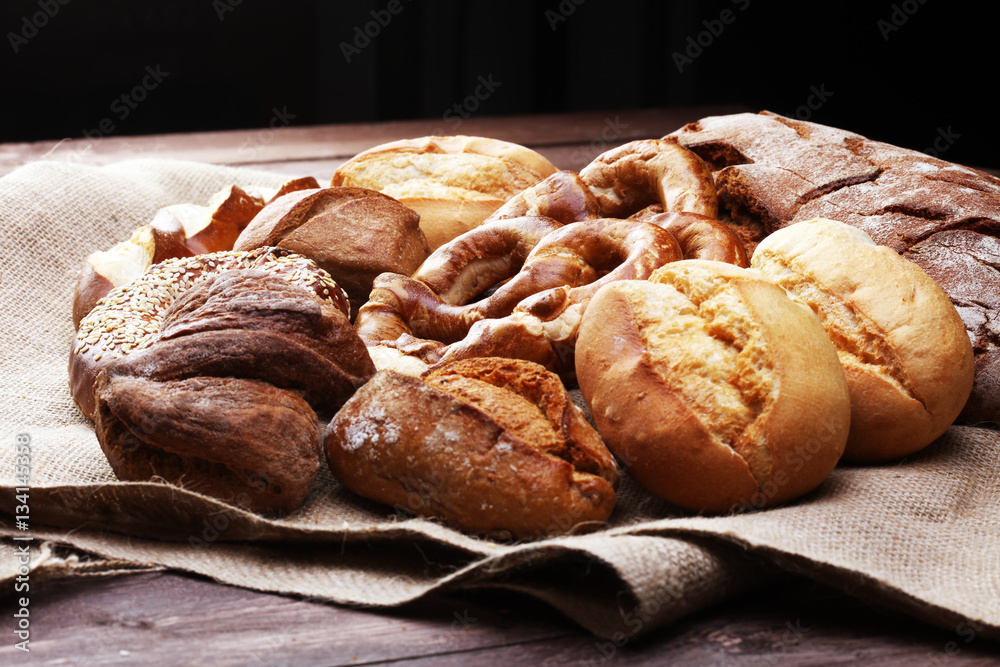 Different kinds of bread and bread rolls on board from above. Kitchen ...