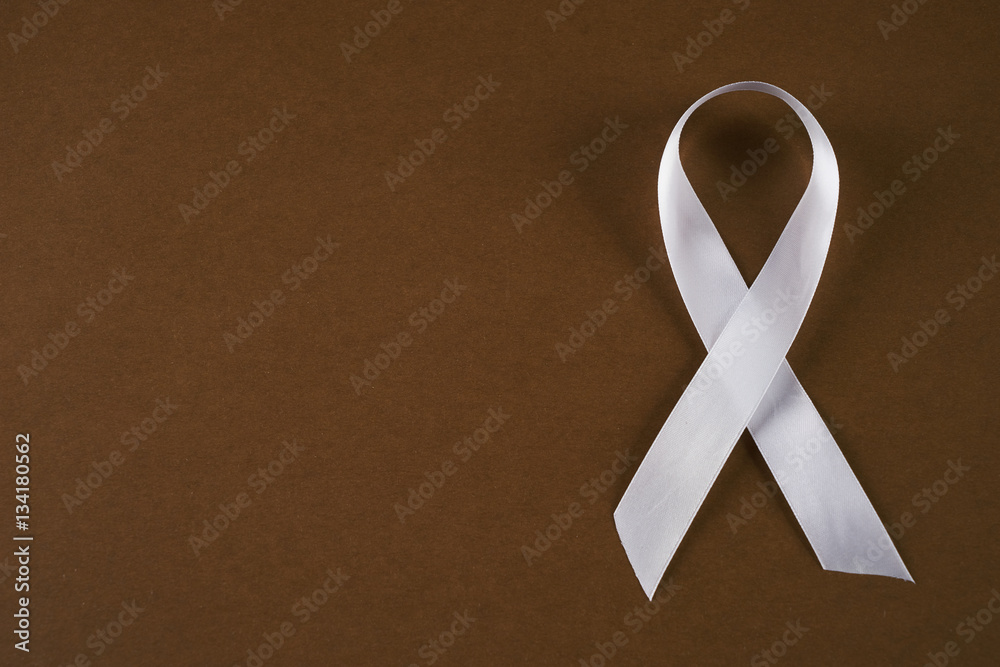 White awareness ribbon on brown background. Symbol of anti violence ...