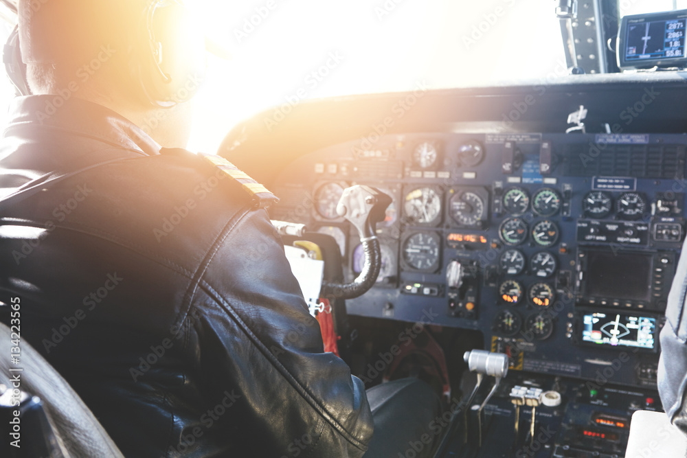 Piloting aircraft. Back view of unrecognizable commercial pilot wearing ...