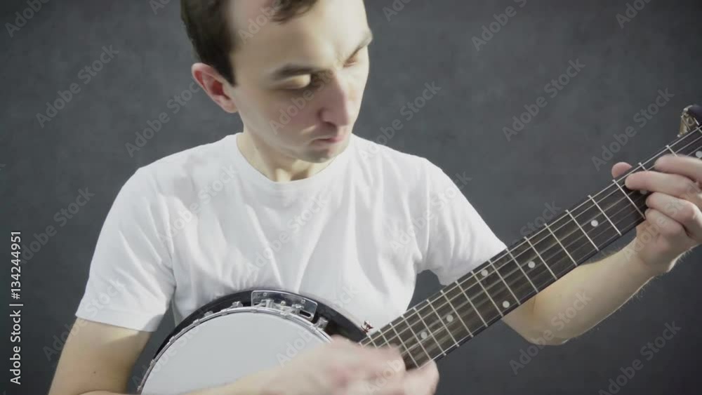 Young guy plays the banjo. Black background Stock Video | Adobe Stock
